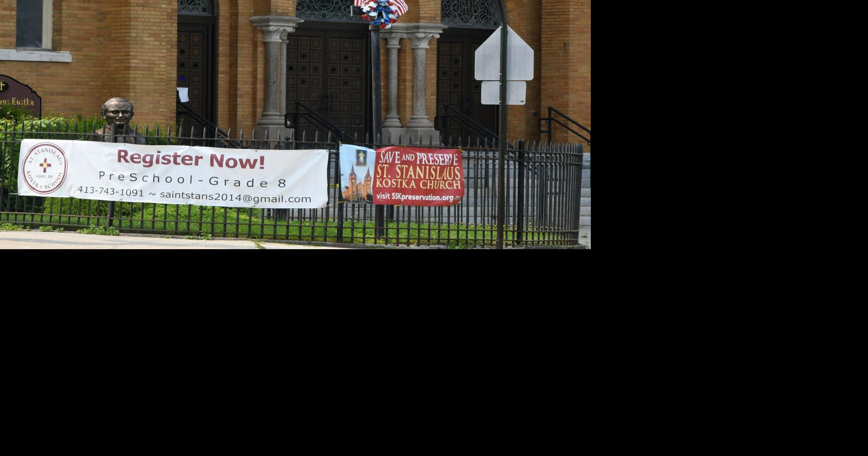 The outside of a church with banners on the iron fence ...