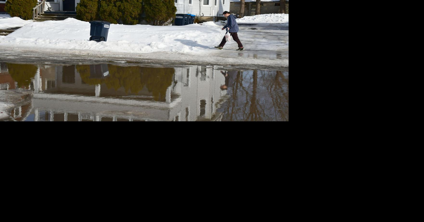 A woman is reflected in a puddle as she walks | | berkshireeagle.com