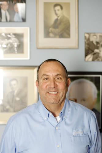 George Haddad in front of family photographs | | berkshireeagle.com