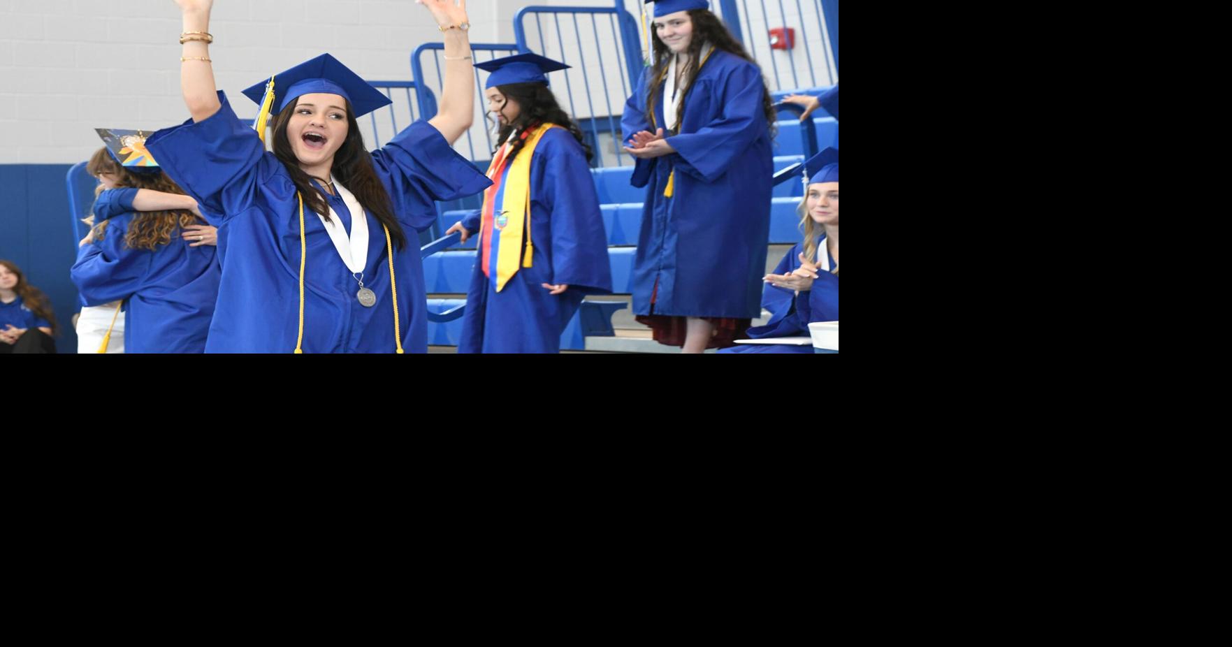 A graduate throws up her hands in the air in celebration | | The ...