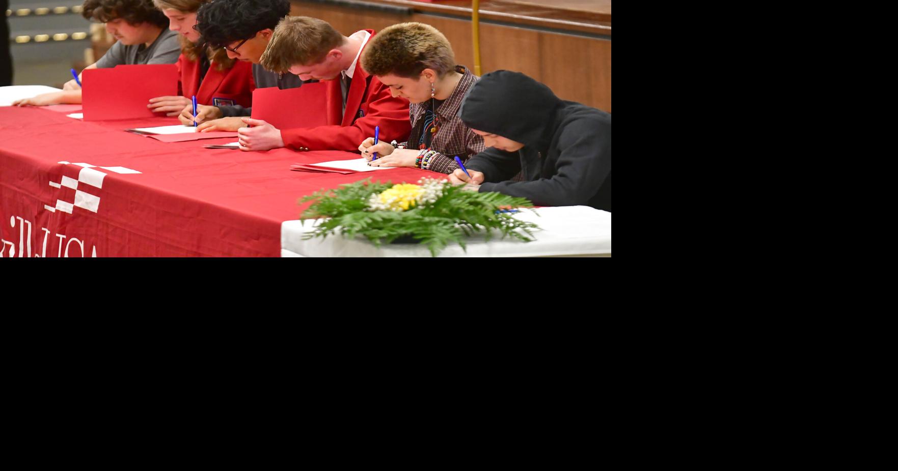 Students sign papers at a table | | berkshireeagle.com