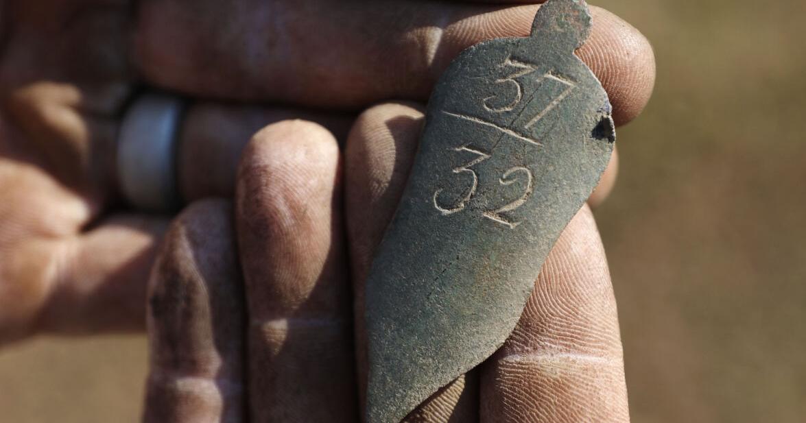 Max Cane holding musket thumb plate engraved with regimental numbers ...