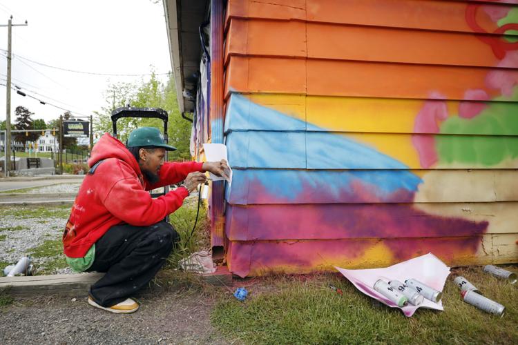 Photos: Artist Maleek Adams paints a mural covering the building at ...