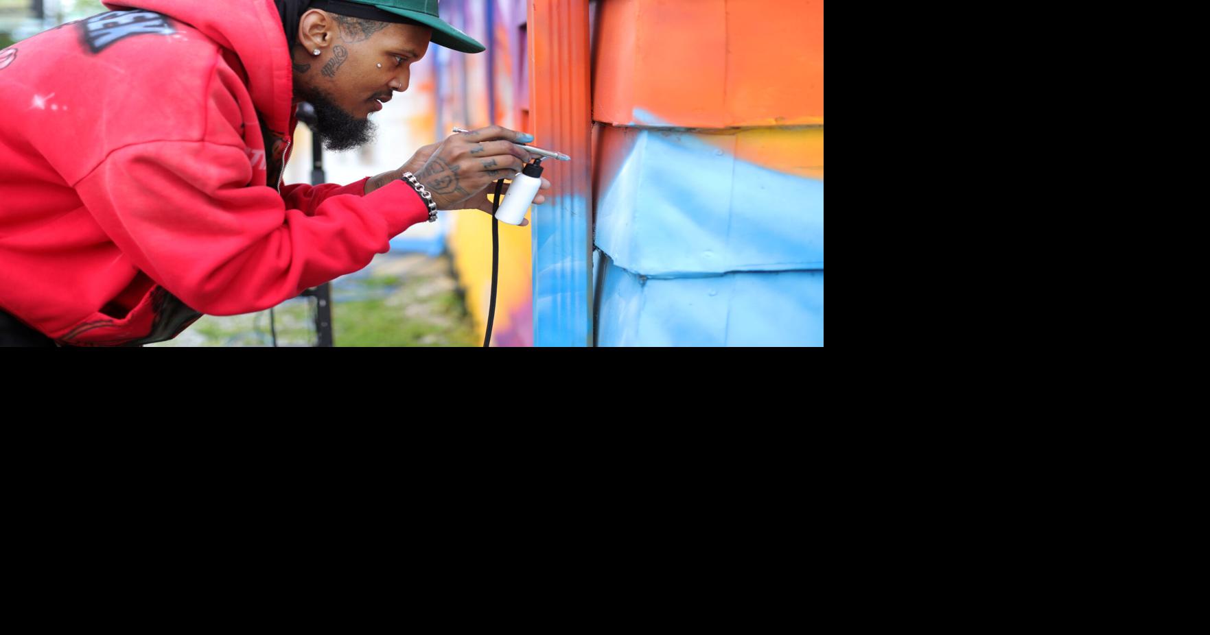 Photos: Artist Maleek Adams paints a mural covering the building at ...