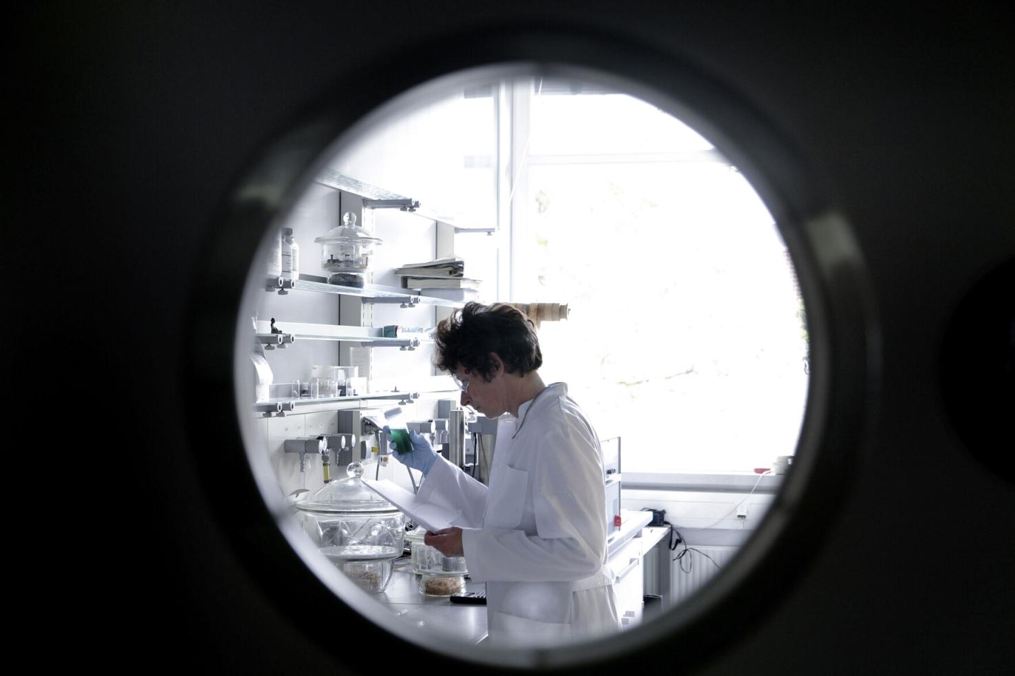 Female chemist working in lab watched through spy hole | | The ...