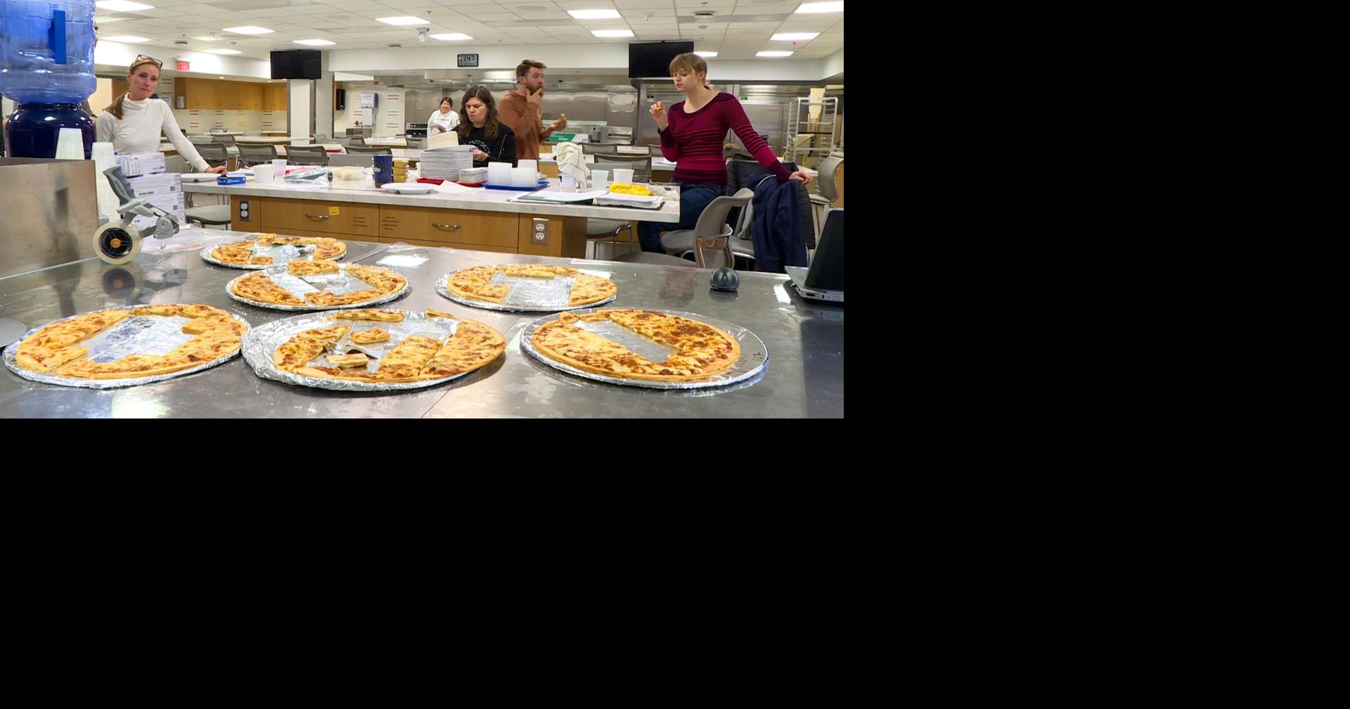 A group of descriptive sensory panelists look over cheese pizzas ...