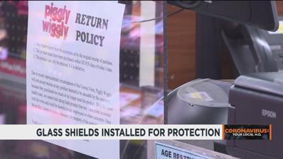 Grocery stores install glass barrier between cashier and customer for ...
