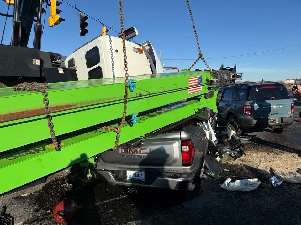 Tractor-trailer carrying crane runs red light, crushes car, sends two ...