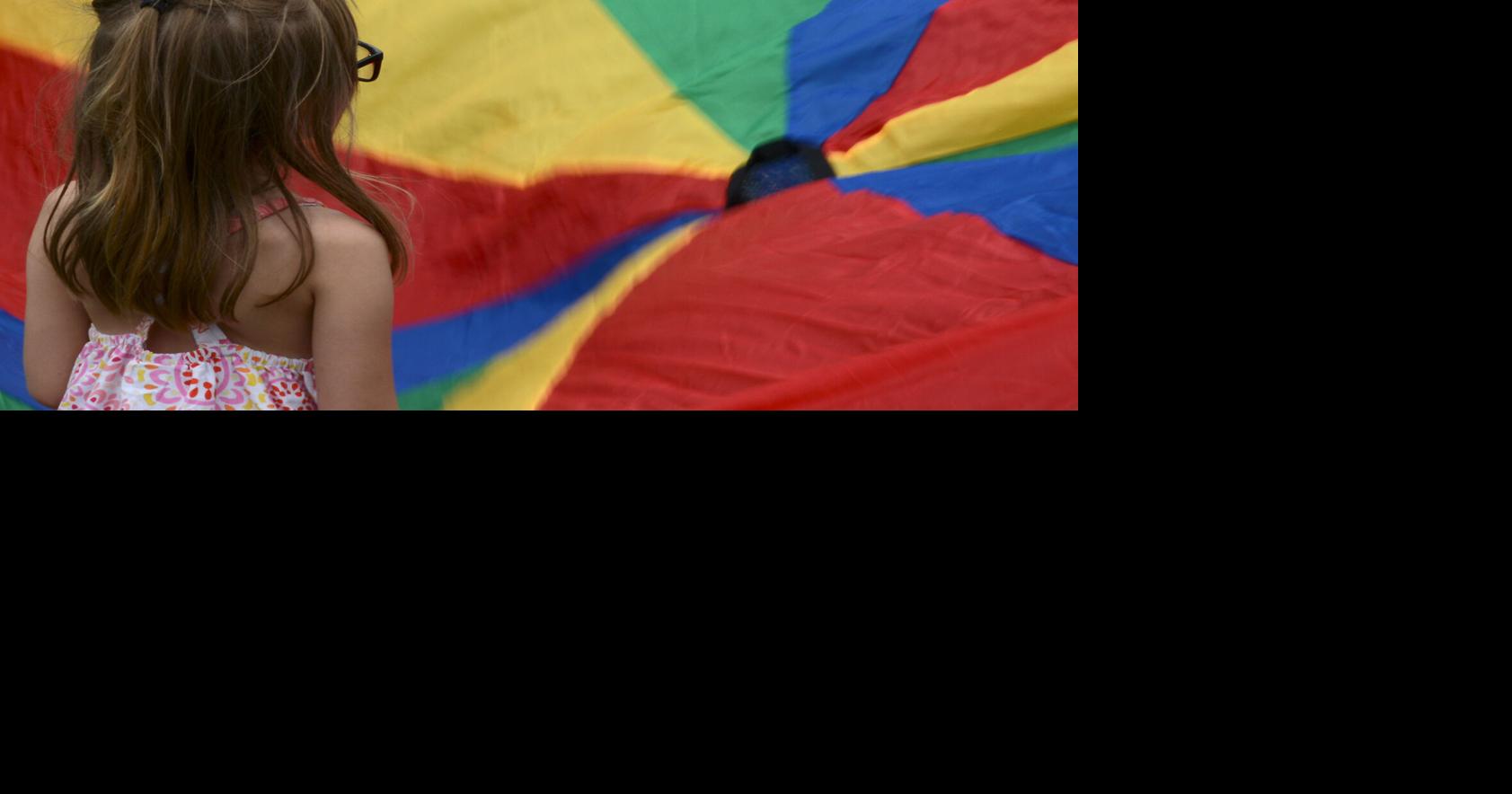 Kahlor Johnston watches children lower a play parachute | Visuals ...