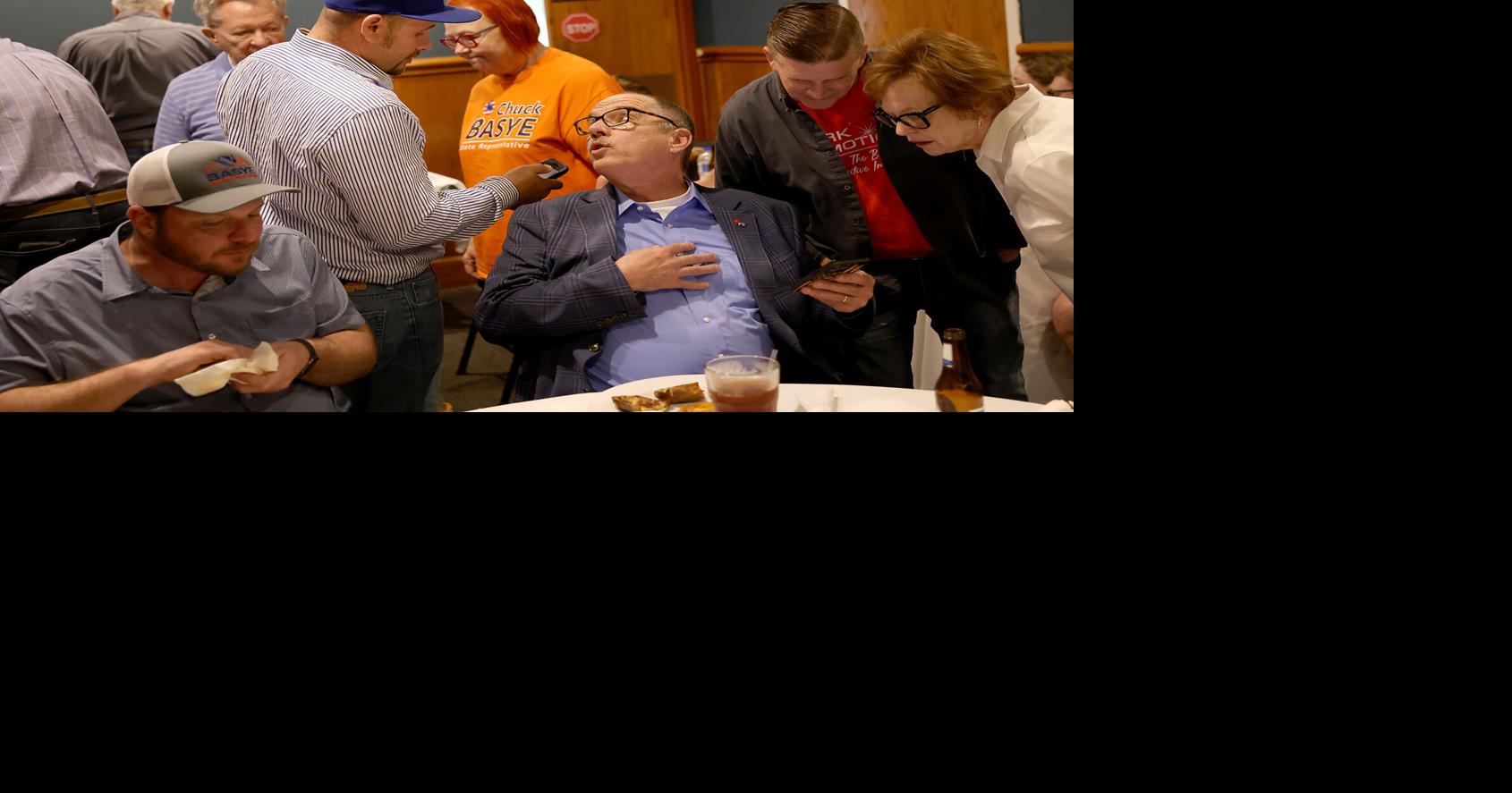 School Board candidates John Potter and Chuck Basye check their phones ...
