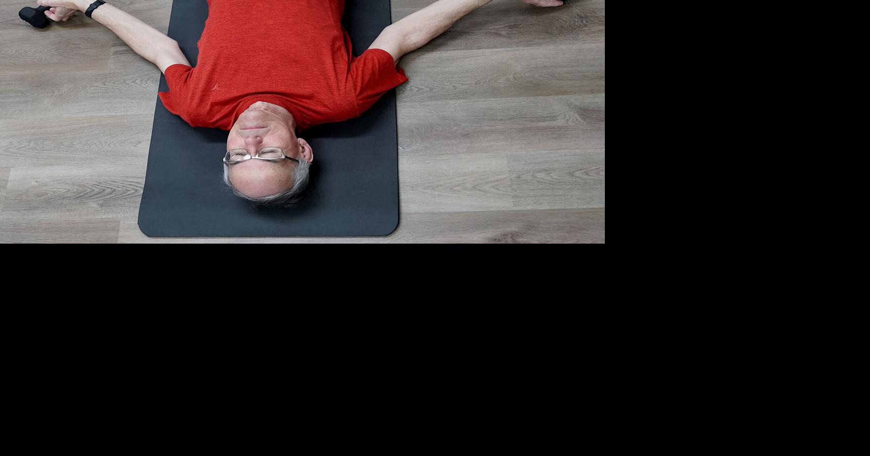George Kracke lies down before doing a dumbbell weight exercise during ...