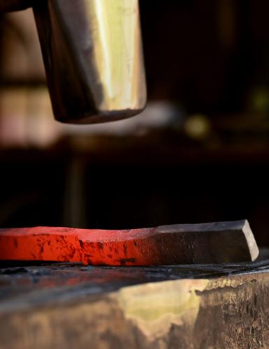 George B. Robb II uses a hammer to bang on a piece of metal | Visuals ...