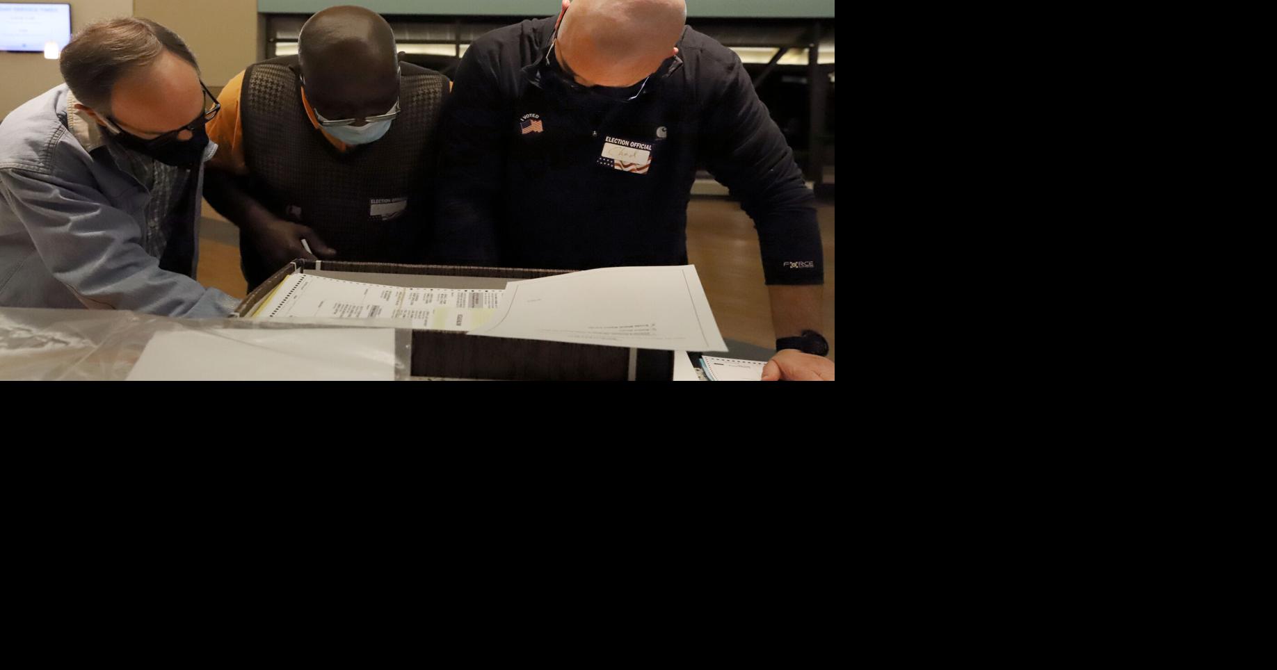 David Mallory, Patrick Ezeji and Chad Hanner look over a checklist ...