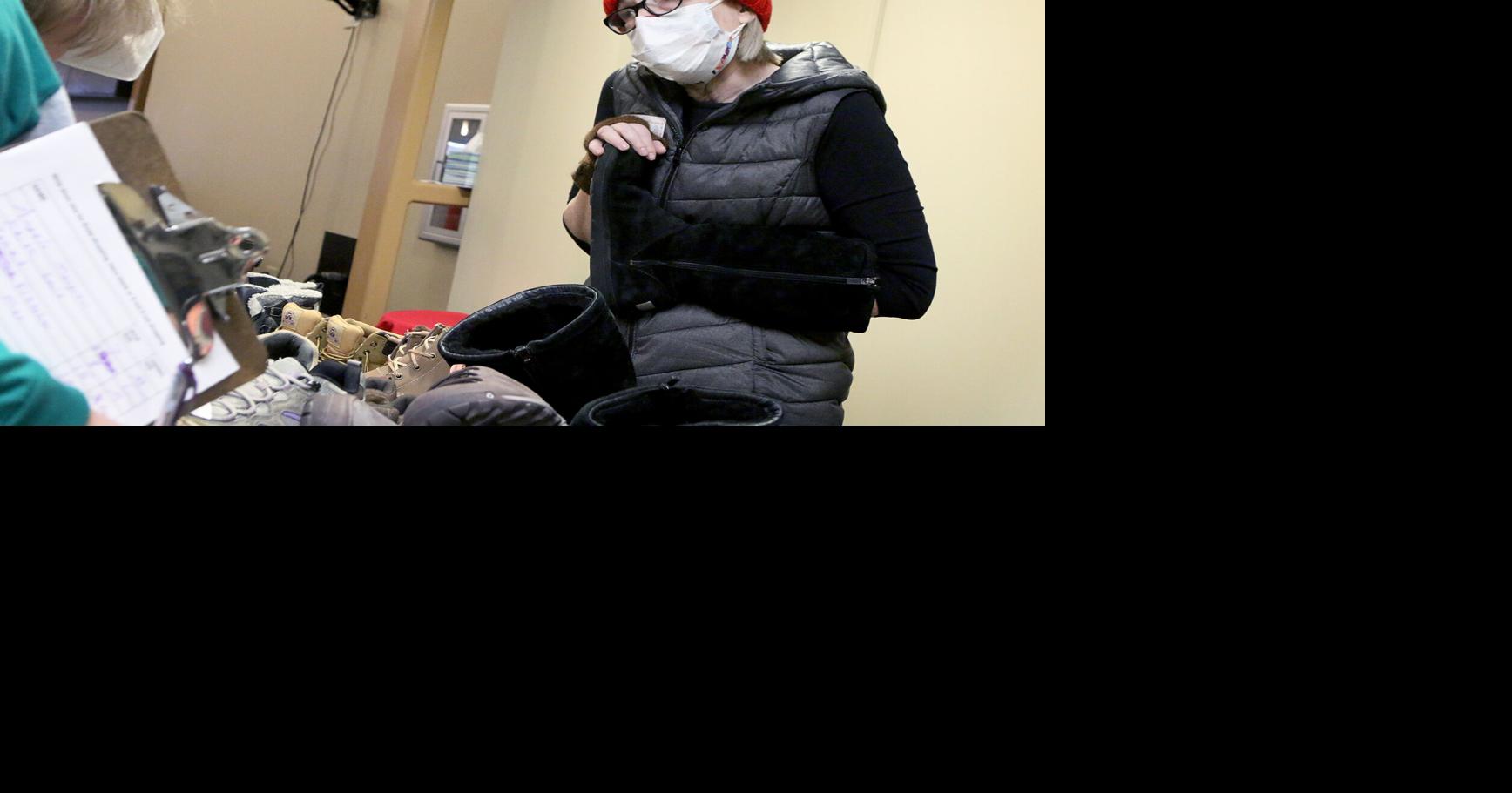 Pat Fowler feels the inside of a winter boot | | columbiamissourian.com