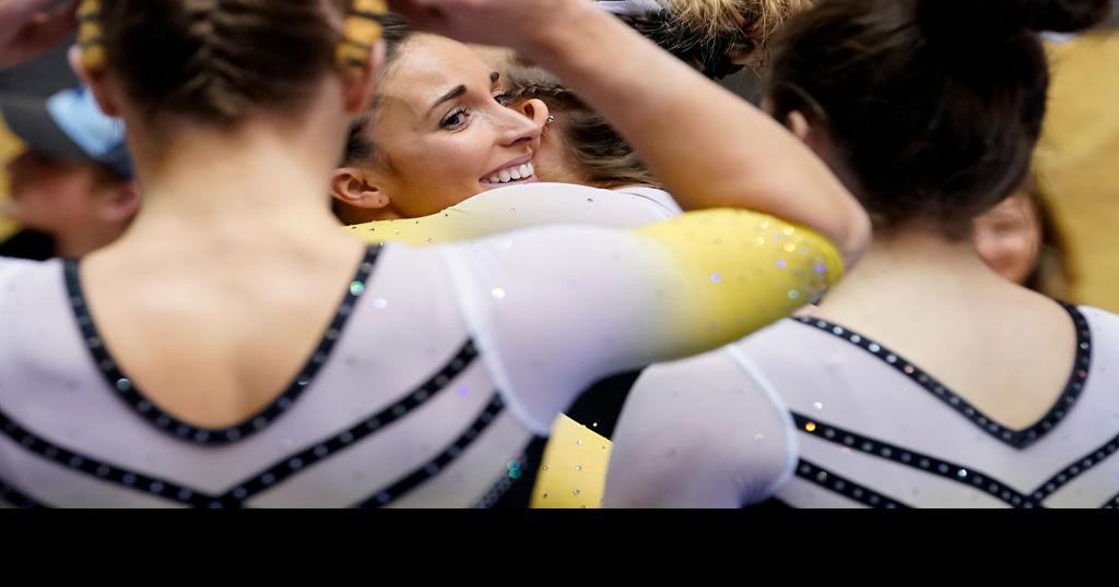 Becca Schugel hugs her teammates after finishing her bar routine ...