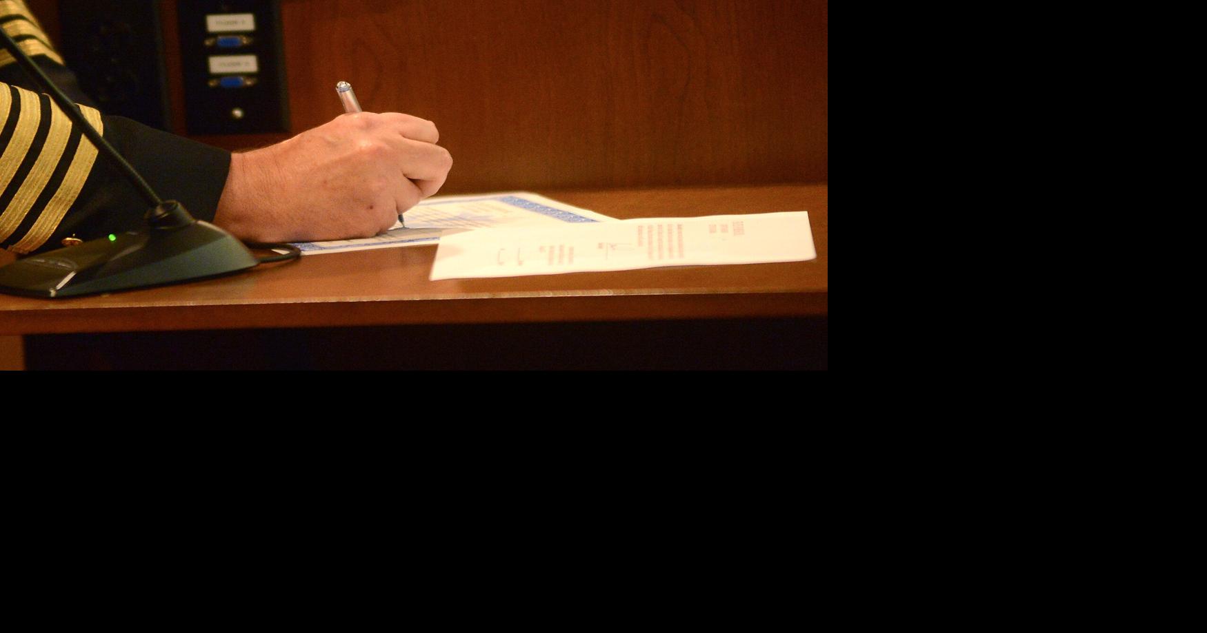 Brian Schaeffer signs a document after taking his oath ...