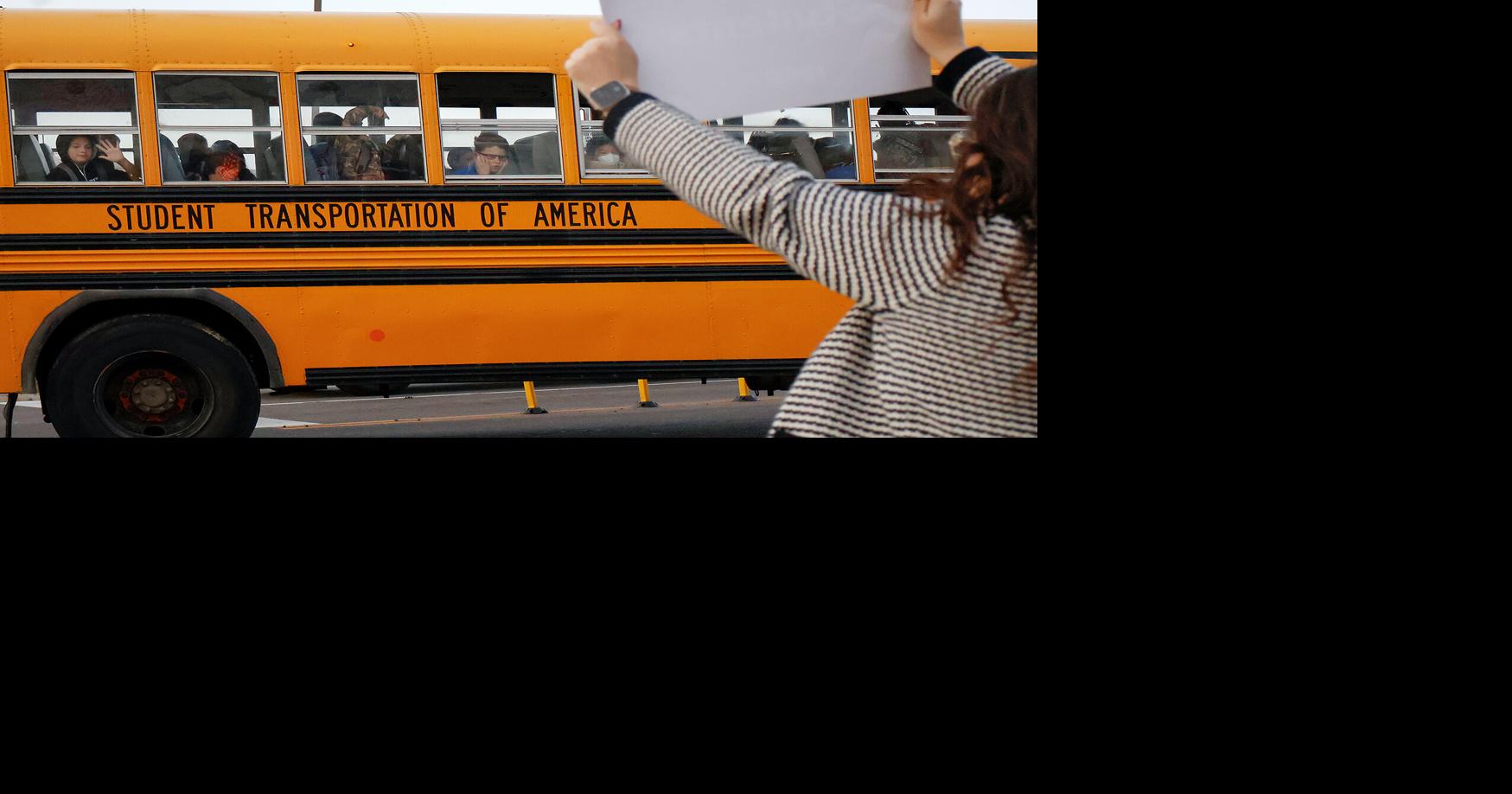 Bused students stare out the windows to witness the commotion raised by ...
