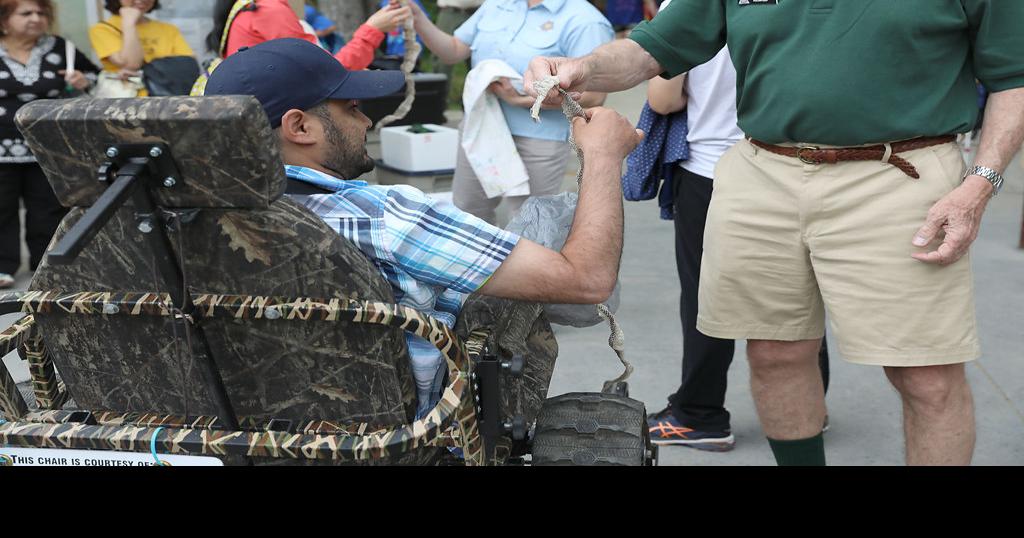 Akram Mahmood, left, touches a snake skin that Stephen Carew hands to ...
