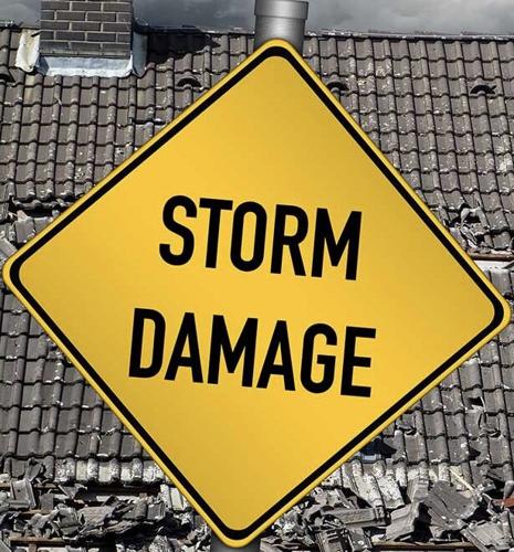 yellow damage warning sign in front of storm damaged roof of house ...