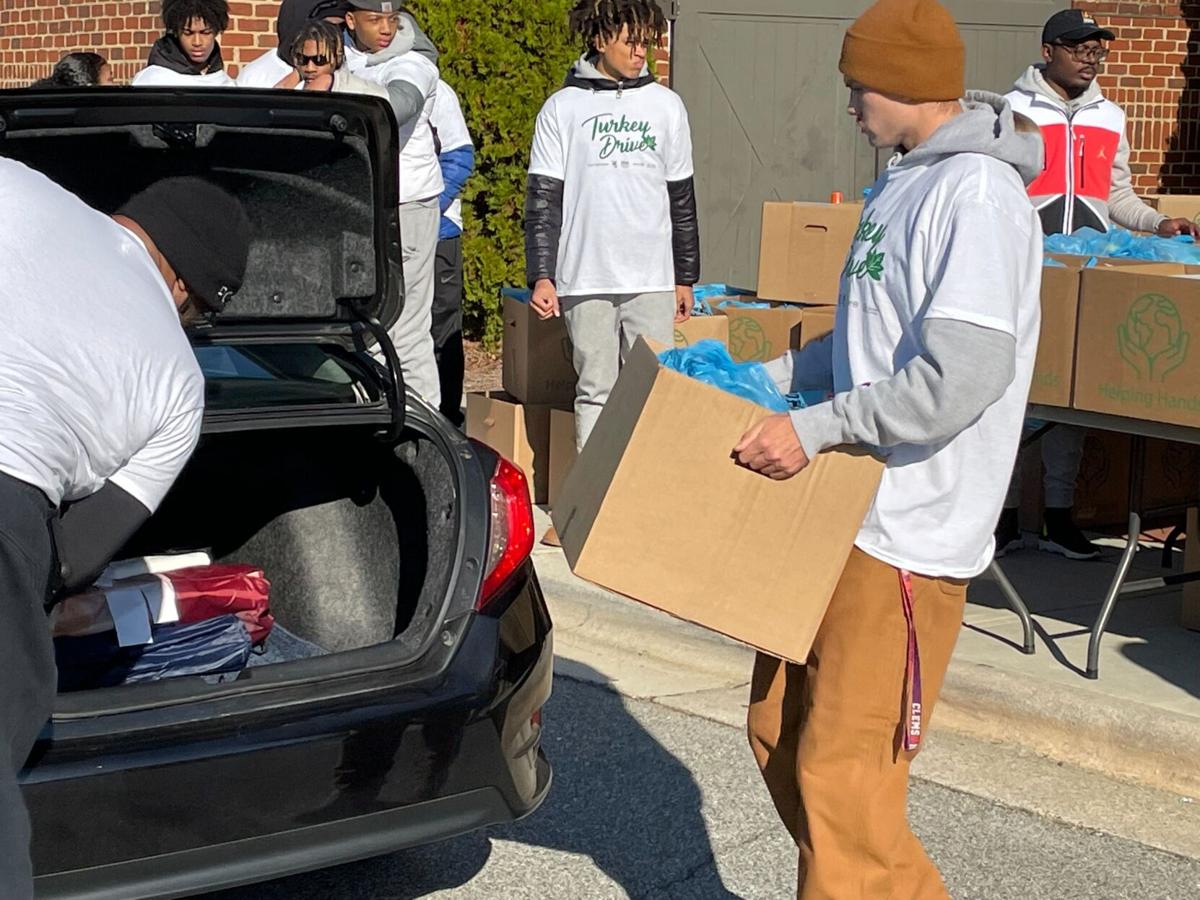 Volunteers distribute turkeys and other food to more than 400 families ...