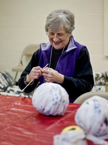 Women make mats for homeless by knitting plastic bag strips