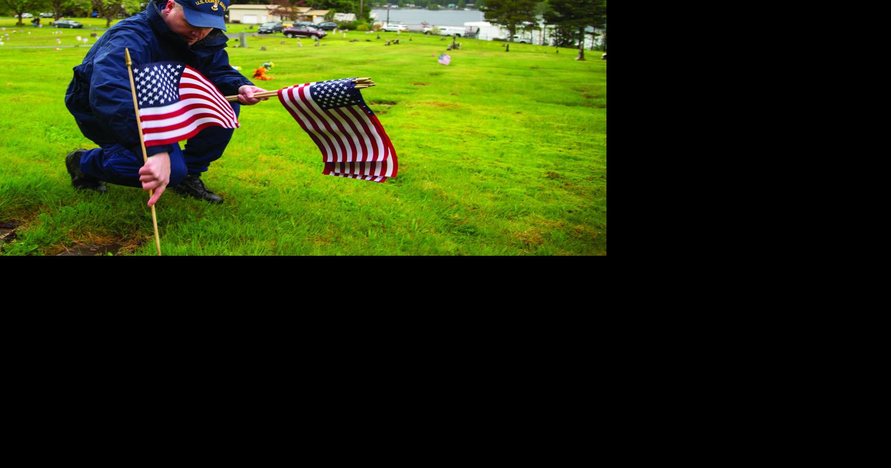 U.S. Coast Guard Chief Ben Kees places flags at Bayview Cemetery ...