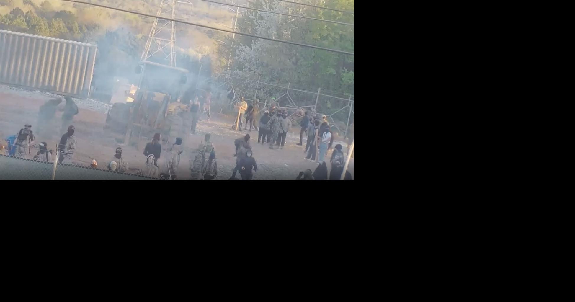 Dozens detained after a construction vehicle was set ablaze and bricks ...