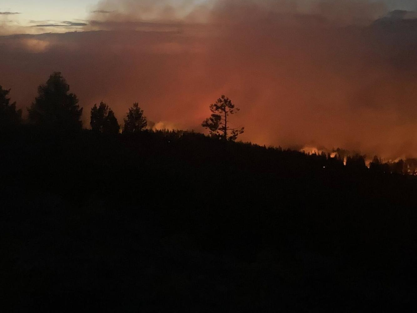 Firefighters work to slow forward progress on fire near the border of ...