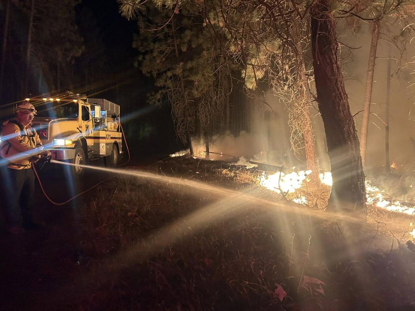 Firefighters work to slow forward progress on fire near the border of ...