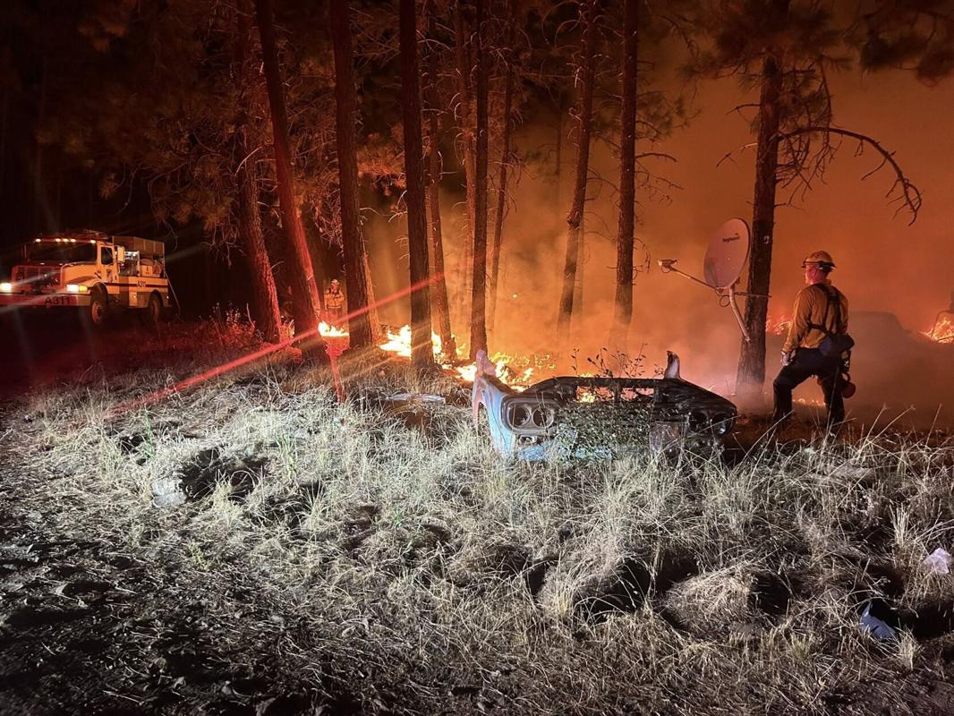 Firefighters work to slow forward progress on fire near the border of ...