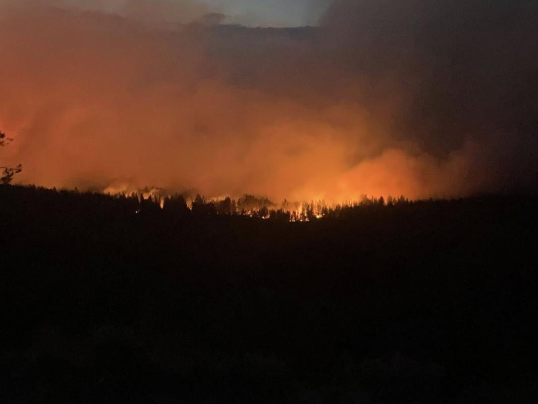 Firefighters work to slow forward progress on fire near the border of ...