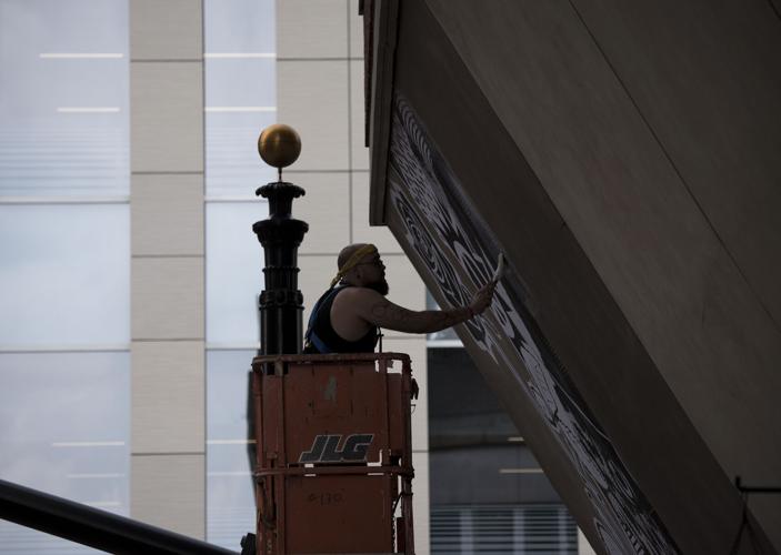 Adam Serrano working on 'Conjuring Giants' mural | | lancasteronline.com