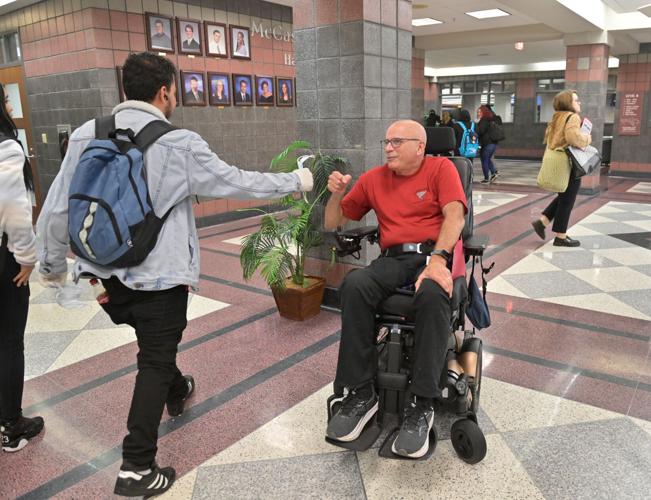 Brother Frank Albrecht greets students as they enter McCaskey East for ...