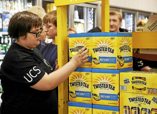 Youth place warning stickers on alcoholic beverage cases for 'Sticker ...