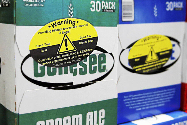 Youth place warning stickers on alcoholic beverage cases for 'Sticker ...