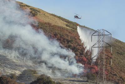 Firefighters battle a wildland blaze in the hills north of Salinas ...