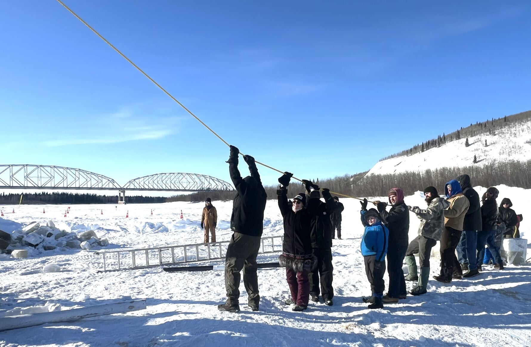 Volunteers raise tripod on Tanana River for Nenana Ice Classic contest ...