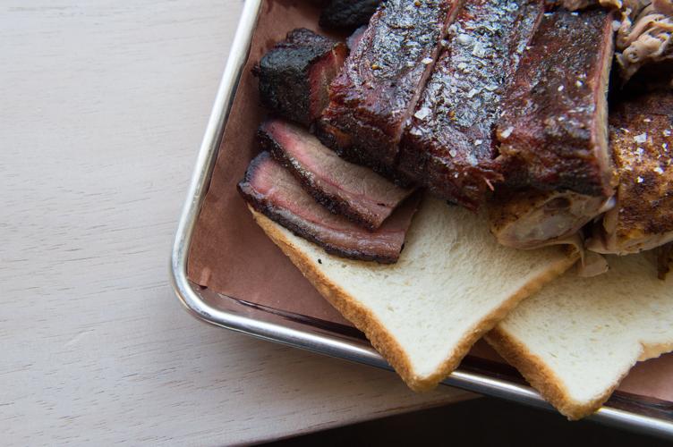 Change at the smoker at Central City BBQ, and shifting coals in a ...