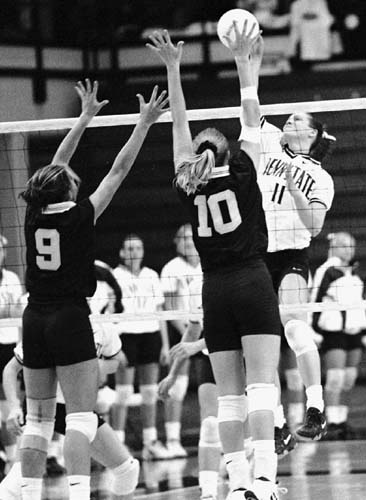 Christy Cochran hitting the ball against two blockers | Archived News ...