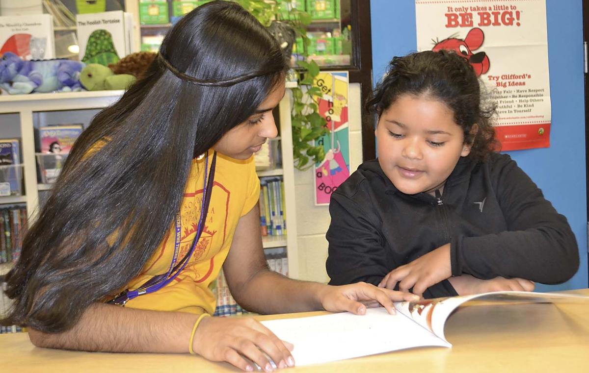 High school students take bilingual books, reading to Lester Elementary