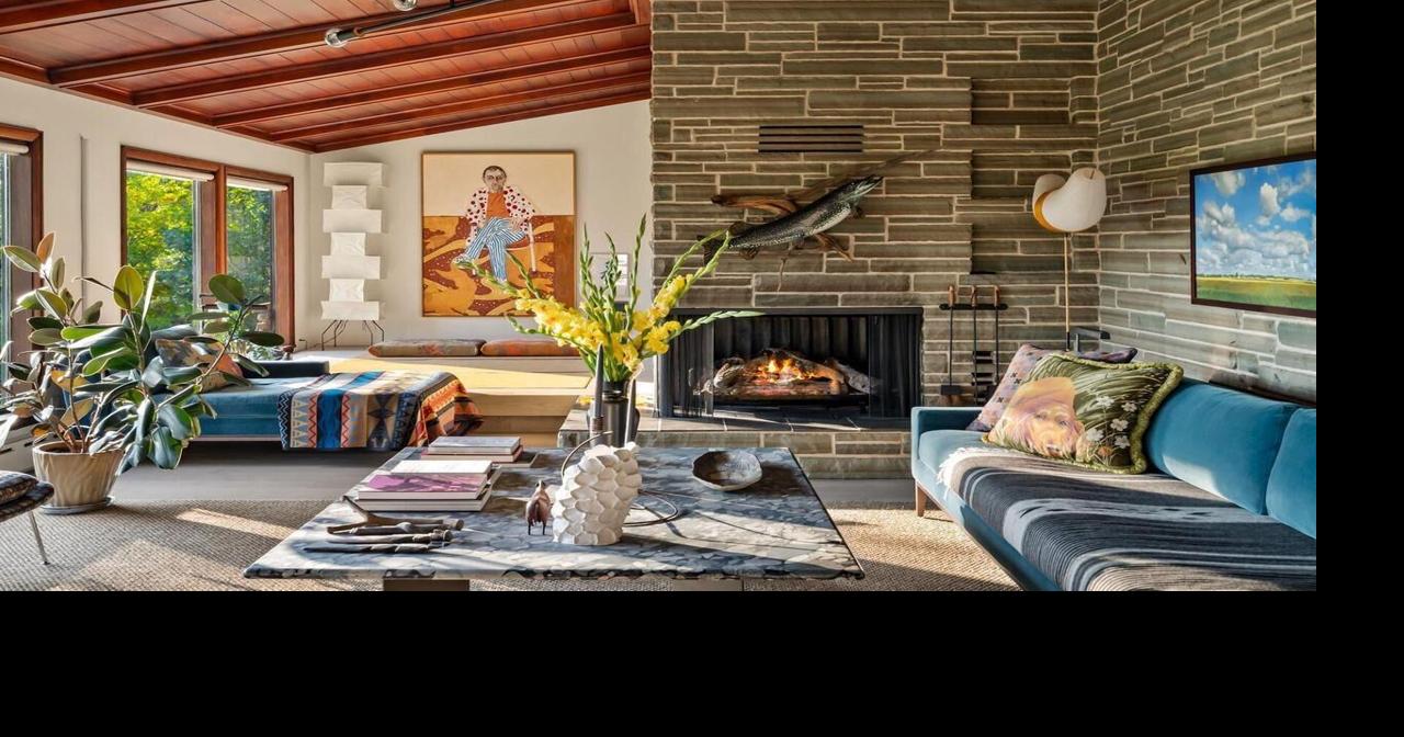 Living area with stone fireplace with abundance of natural light ...