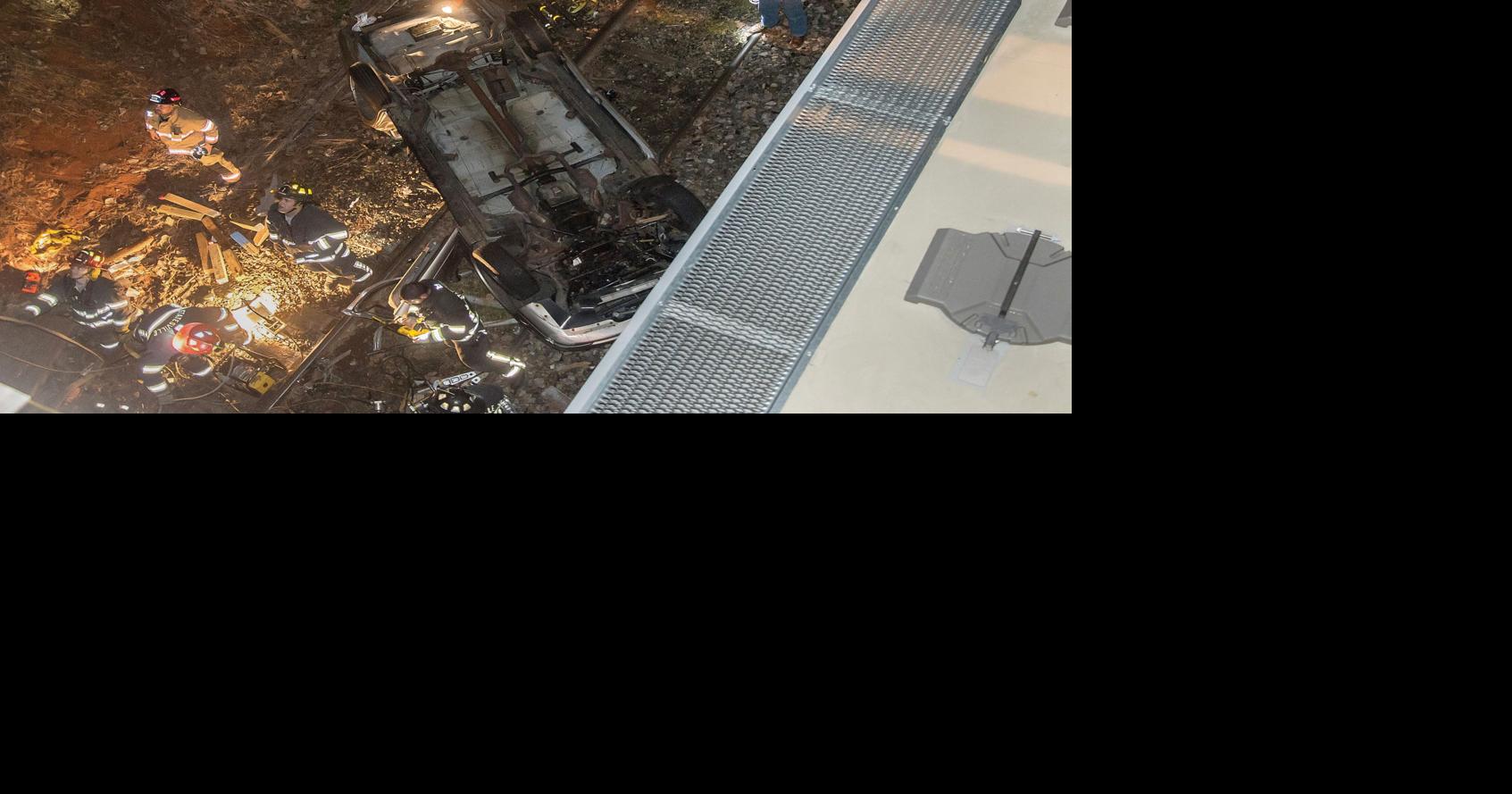 Car drives off bridge, onto railroad tracks; driver injured