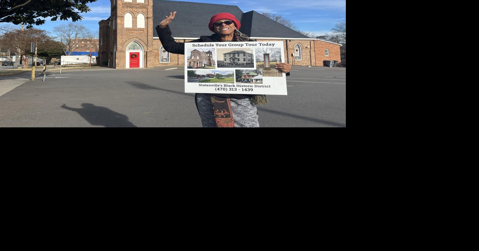 Lisa Mozer stands with a sign offering tours of the area she hopes ...