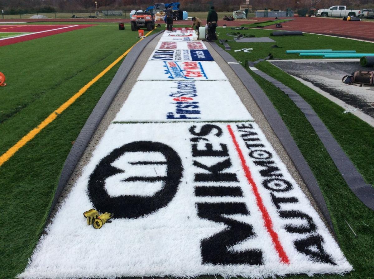Ads are installed on football fields' turf at Belleville high schools