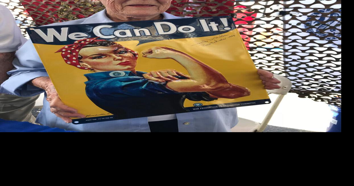 Jennifer McMullen holds a "Rosie the Riveter" poster at an air show in ...