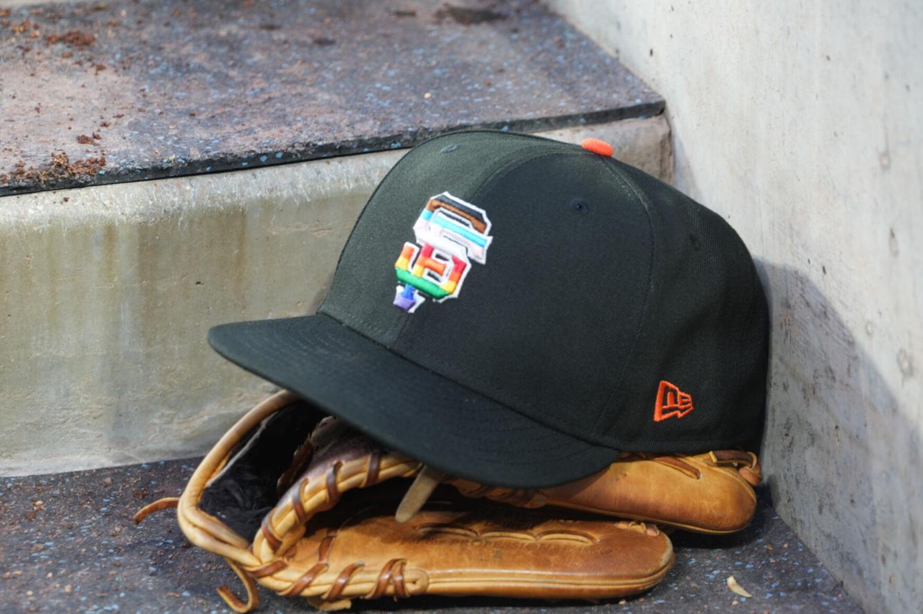 A rainbow colored San Francisco Giants logo cap and a glove in the ...