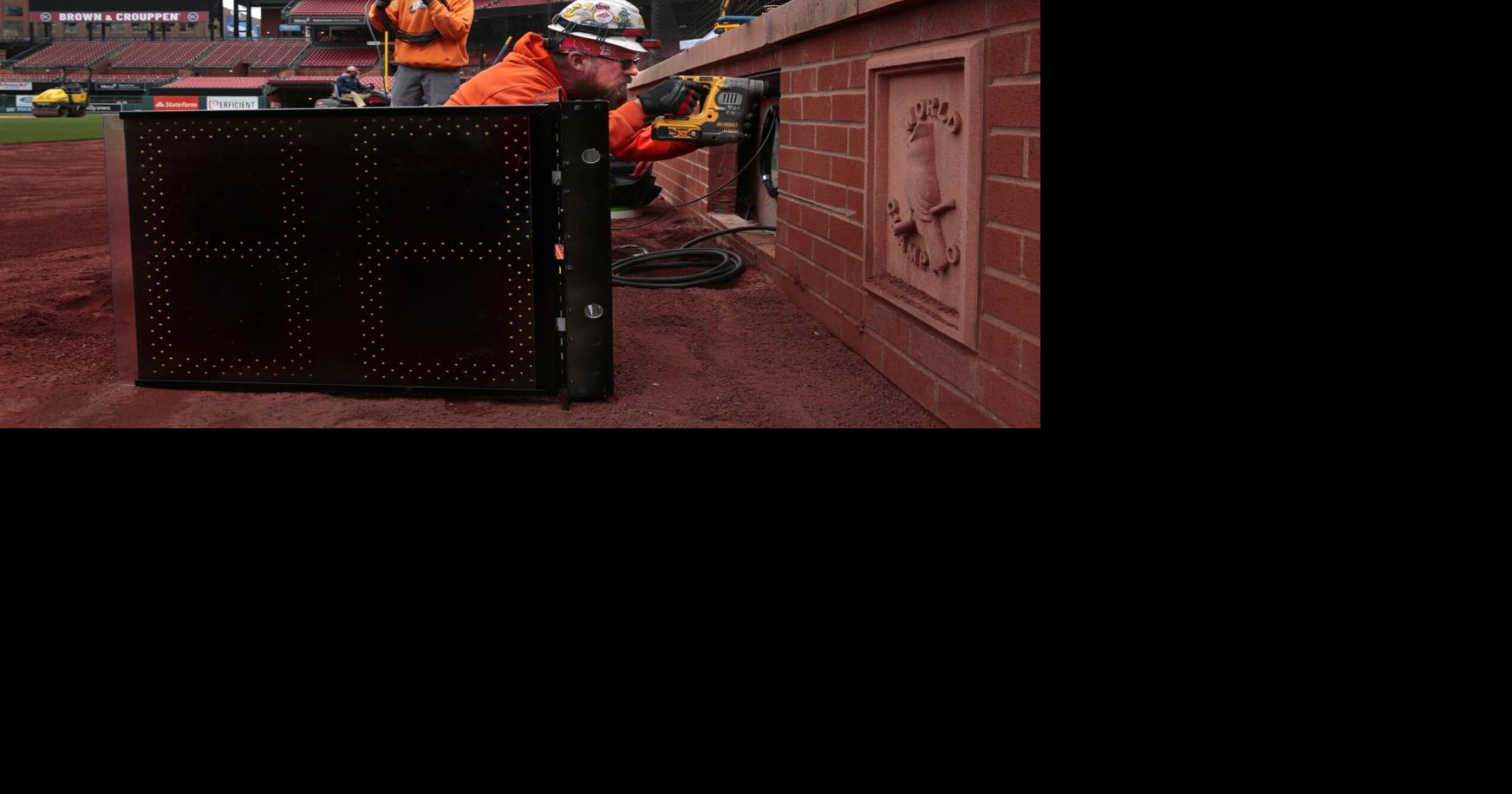 Workers install pitch clocks at Busch Stadium