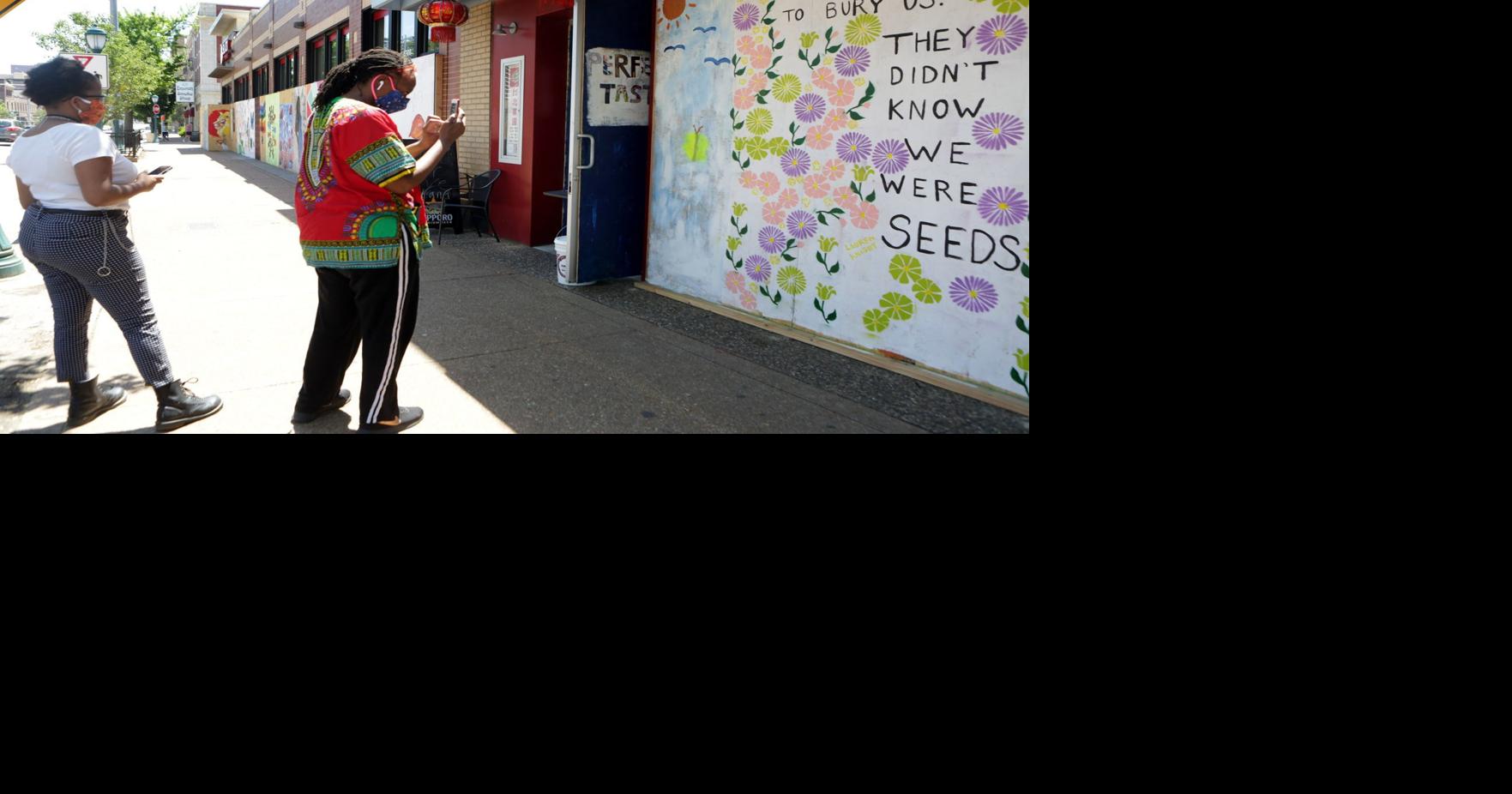 Photos: Artists paint boarded-up windows with messages of hope