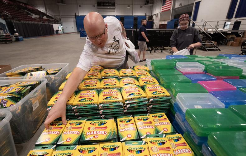 Volunteers in Dubuque pack bags of school supplies for St. Mark ...