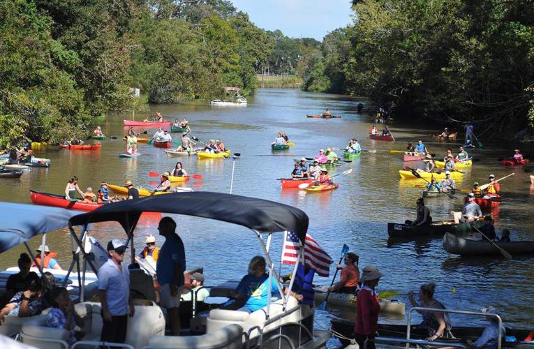 Spectators line the banks of Bayou Vermilion Sunday to watch the boat ...
